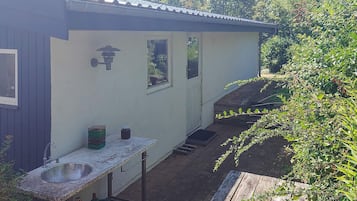 Uma casa com cozinha, incluindo uma pia e uma janela.