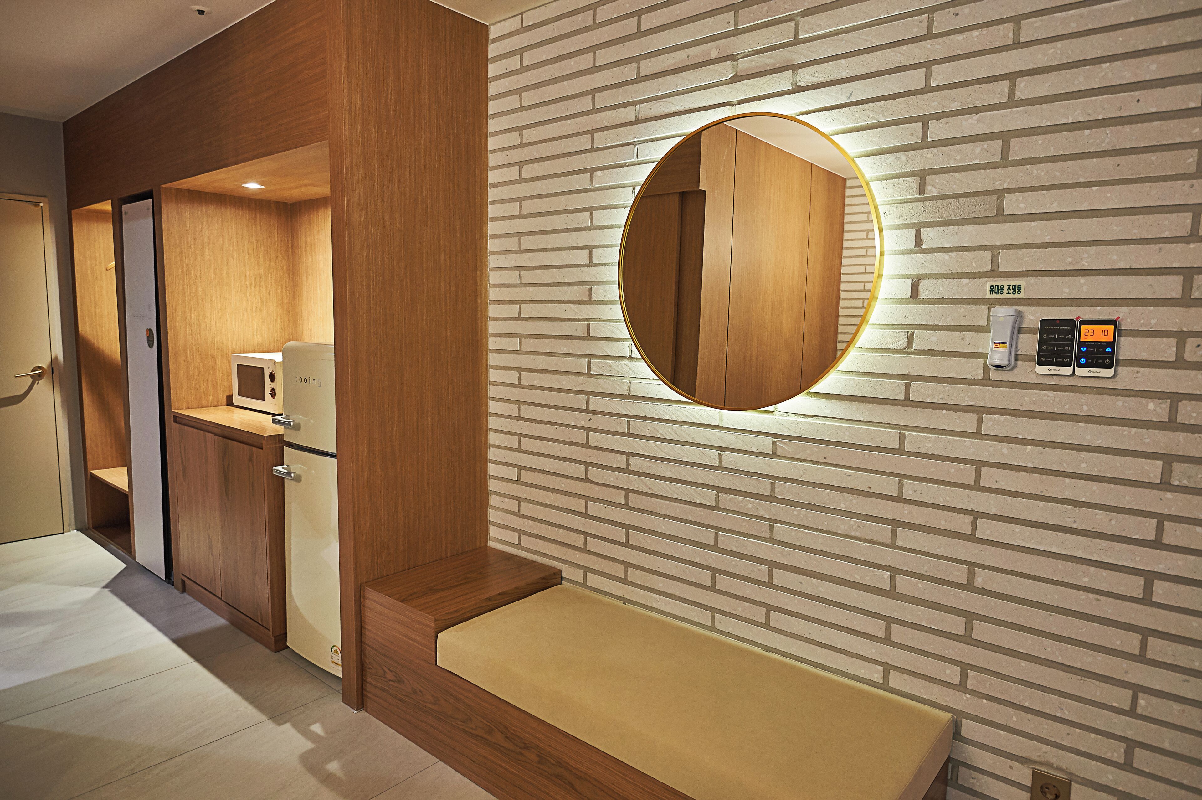 A modern bathroom with a wooden vanity, a round mirror, and a built-in sink.