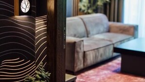 Um interior moderno com um sofá, um relógio e uma planta.