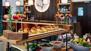 Uma mesa de buffet com diversos aperitivos e uma saladeira.