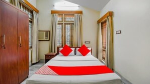 Um quarto com uma cama, cortinas, um guarda-roupa e uma janela.