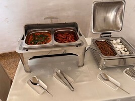 Disposição de buffet com diversos alimentos e utensílios.