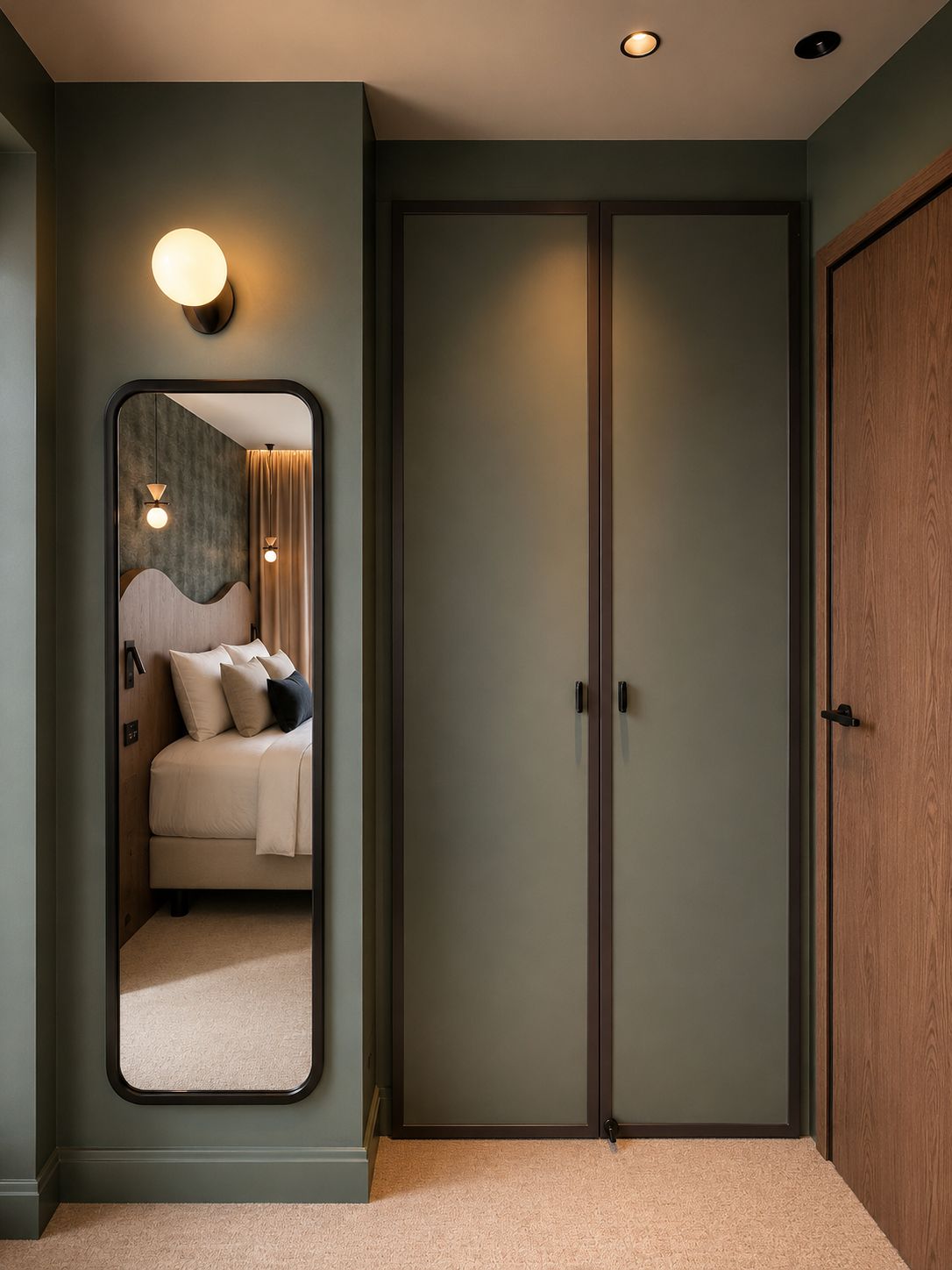 Um quarto com uma cama, um espelho e uma porta.
