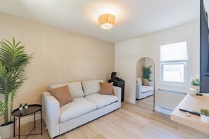 Uma sala de estar moderna com um sofá, mesa de centro e plantas em vasos.