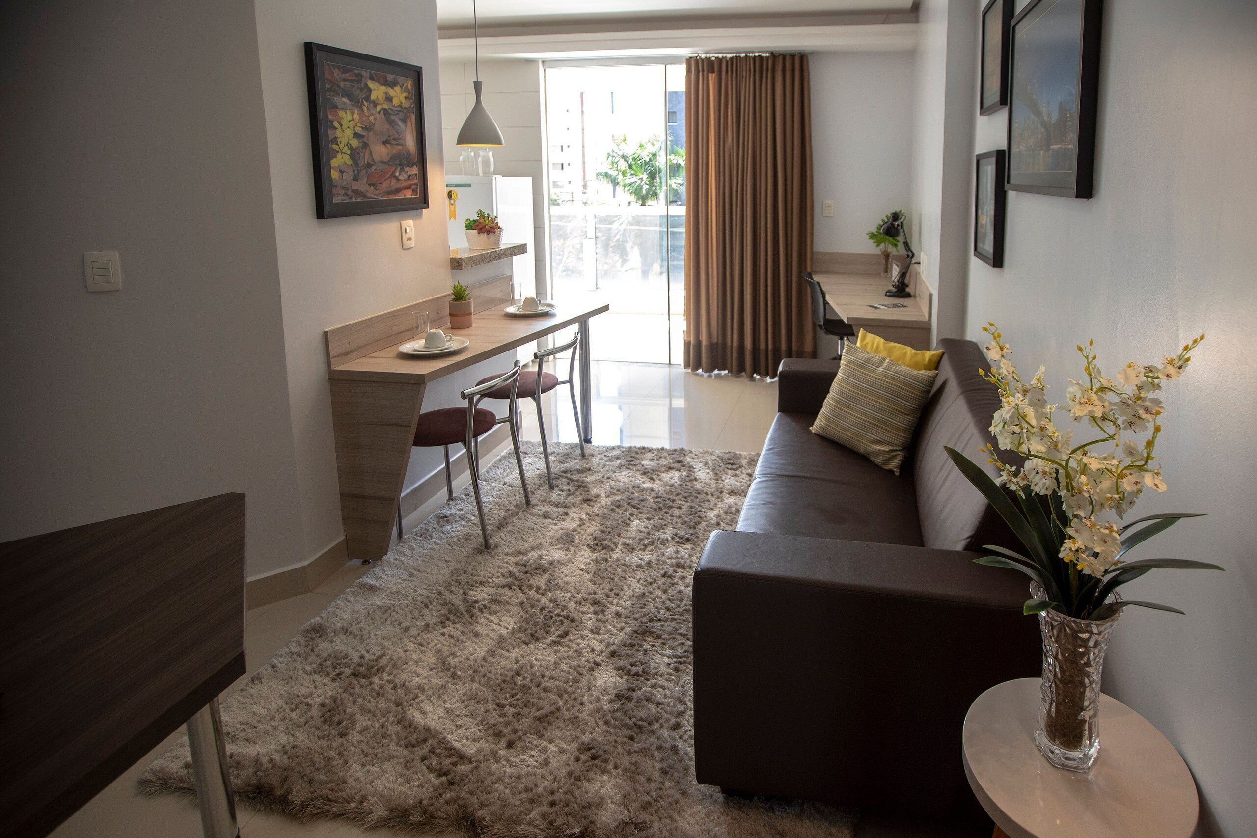 Uma sala de estar moderna com um sofá, uma mesa de jantar e uma mesa de centro.