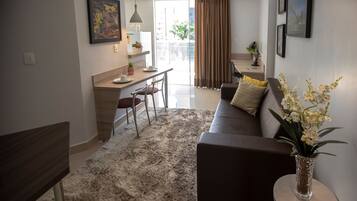 Uma sala de estar moderna com um sofá, uma mesa de jantar e uma mesa de centro.