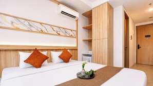 Quarto de hotel com cama, cabeceira com design em mármore, unidade de ar condicionado e guarda-roupa de madeira.
