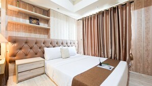 Uma cama bem arrumada com cabeceira marrom, uma mesinha de cabeceira com gavetas e uma prateleira sobre a cama.