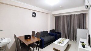 Um espaço compacto com mesa de jantar, sofá e uma pequena cozinha equipada.
