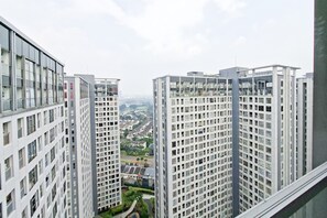 Um edifício alto com vários andares, janelas grandes e vista para a paisagem urbana.