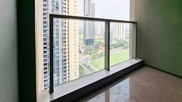 Uma janela com vista para edifícios altos e uma estrada.
