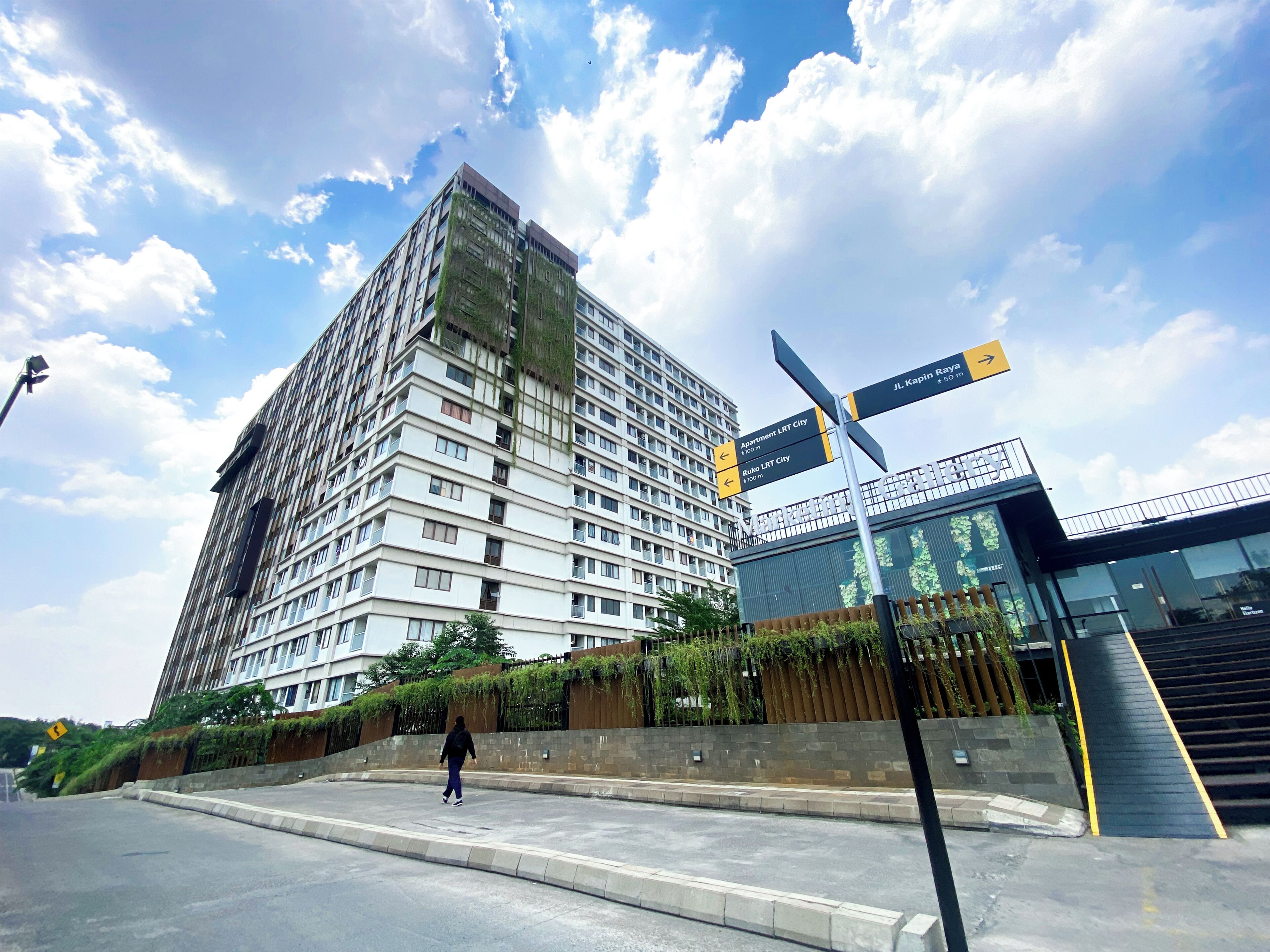 Um edifício moderno com uma placa indicando direções para diversos locais.