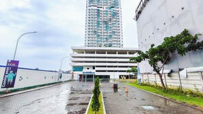 Um edifício de vários andares com estacionamento subterrâneo, uma faixa central verde e uma placa com a inscrição SAIM.