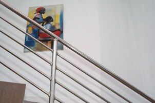 Uma escada com guarda-corpos de metal e um quadro na parede.