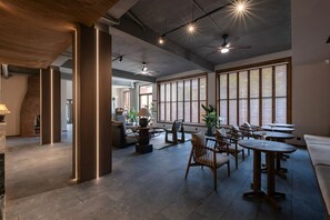 Amplo espaço interno com pé direito alto, dutos aparentes e grandes janelas.