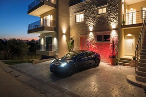 Um edifício moderno de dois andares com um carro estacionado na frente.
