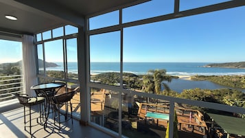 Varanda com vista para o oceano e área de piscina.