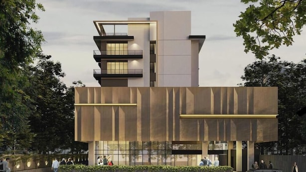 Um edifício moderno de vários andares, com varandas, grandes janelas e telhado plano.