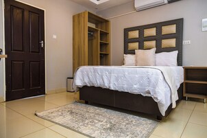 Quarto com cama, guarda-roupa, cabeceira e estante embutida.