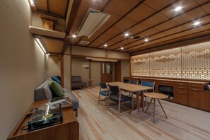 Um interior moderno com área de refeições, sofá e cozinha.