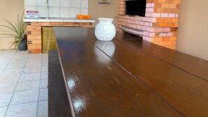 Uma cozinha com painel de azulejos, forno de tijolos e prateleira azul com enfeites de peixe.