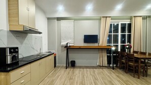 Uma cozinha moderna com armários de madeira, bancada preta e forno embutido.