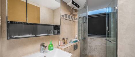 Uma casa de banho moderna com lavatório branco, sanita e cabine de duche com vidro.