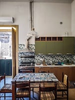 Cozinha com fogão a gás, luminária pendente e backsplash estampado.