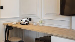 Cozinha moderna com bancada de madeira, um tablet exibindo uma galeria de fotos, um vaso com flores e uma cadeira preta.