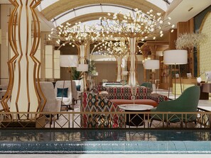 Um saguão de hotel com piscina, áreas de estar e uma estrutura decorativa em forma de árvore.