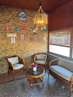 Um quarto acolhedor com mobiliário de vime, uma placa de recepção e um lustre decorativo.