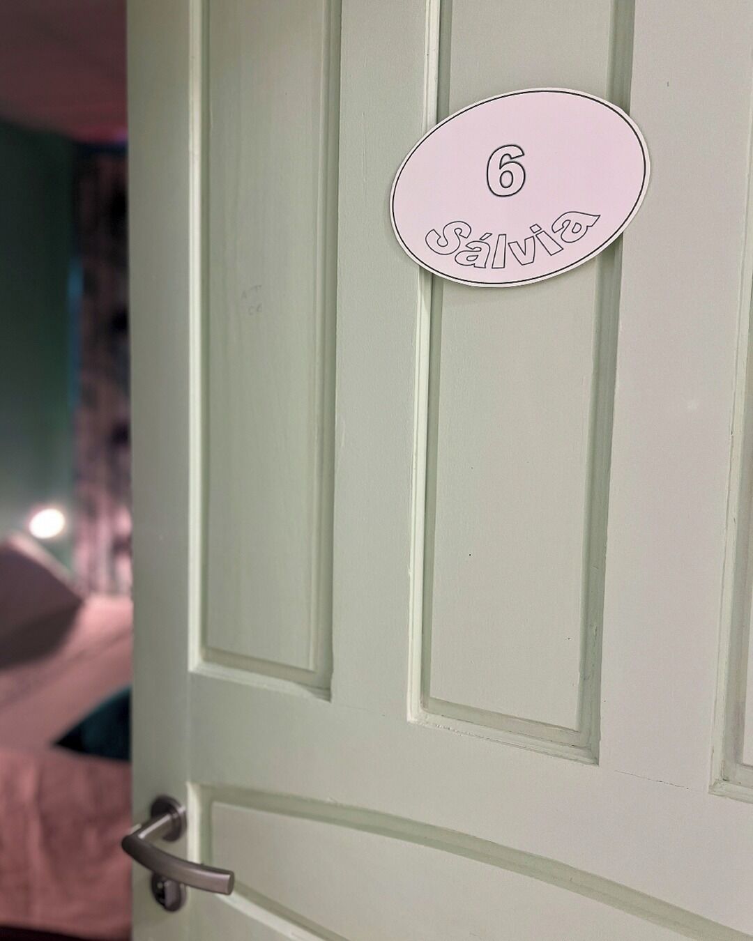 Uma porta com uma placa indicando o número do quarto 6.