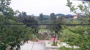Uma área de jardim com uma instalação de luz em formato de coração, um banco e um caminho.