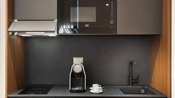 Cozinha moderna com micro-ondas embutido, máquina de café e pia.