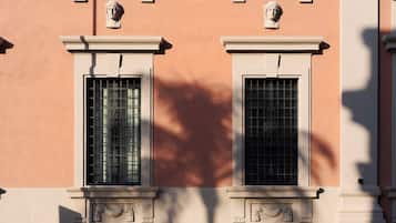 Fachada de edifício com duas janelas, molduras decorativas e um pilar central.