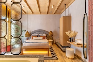 Quarto moderno com cama, mesa de cabeceira, abajur e um vaso decorativo.