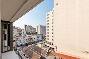 Um edifício alto com vários andares, uma varanda e vista para a paisagem urbana.