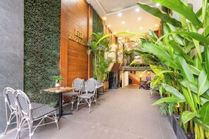 Um hall de hotel com parede de madeira, escada e plantas em vasos.
