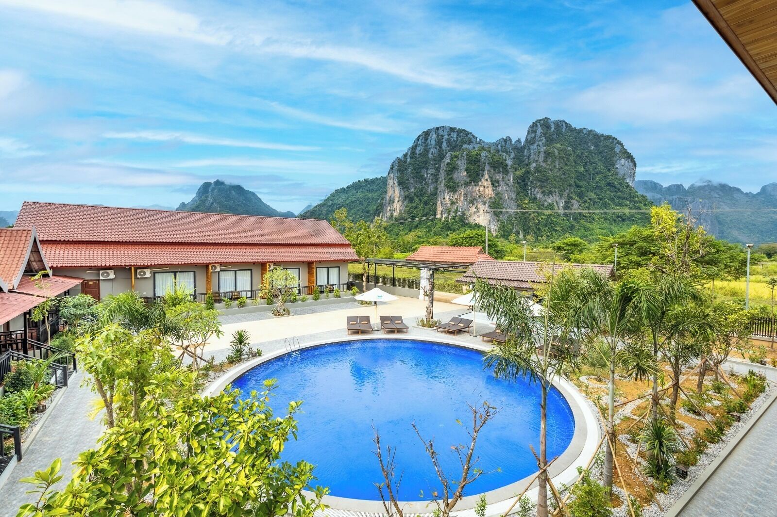 Um hotel com piscina, área de estar externa e vista para montanhas.
