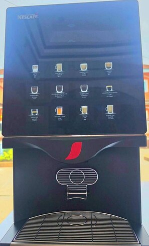 Máquina de café Nescafe com diversas opções de bebidas visíveis.