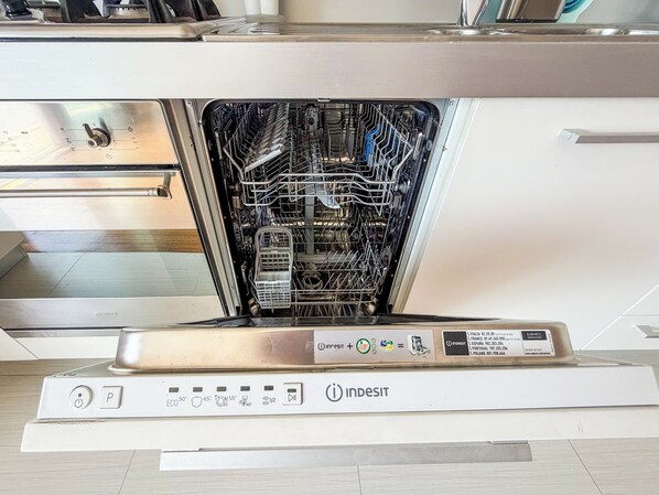Uma máquina de lavar louça aberta, com grelhas internas em aço inoxidável e um painel de controle com diversas configurações.