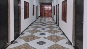 Um corredor com piso estampado, portas e uma porta central no final.