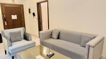 Uma sala de estar com sofá, poltrona e mesa de centro.