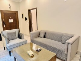 Uma sala de estar com sofá, poltrona e mesa de centro.