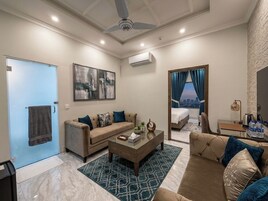Uma sala de estar moderna com um sofá, mesa de centro e vista para a cidade através de uma janela.