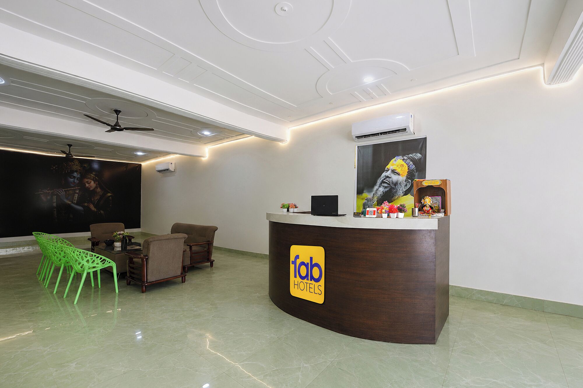 Uma área de recepção de hotel com um balcão curvo, um ventilador de teto e um ar condicionado fixado na parede.