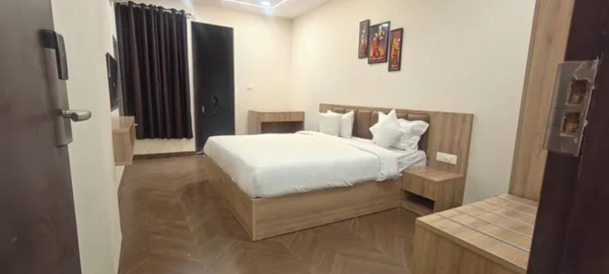 Quarto de hotel com uma cama, mesas de cabeceira, um guarda-roupa e uma porta.