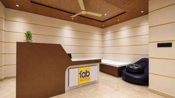 Uma área de recepção de hotel com design moderno, incluindo balcão de atendimento, espaço de estar e um ventilador de teto.