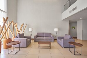 Uma sala de estar moderna com um sofá, duas mesas laterais e uma mesa de centro.