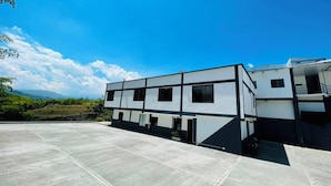 Um edifício moderno com telhado plano e um terraço amplo e aberto.